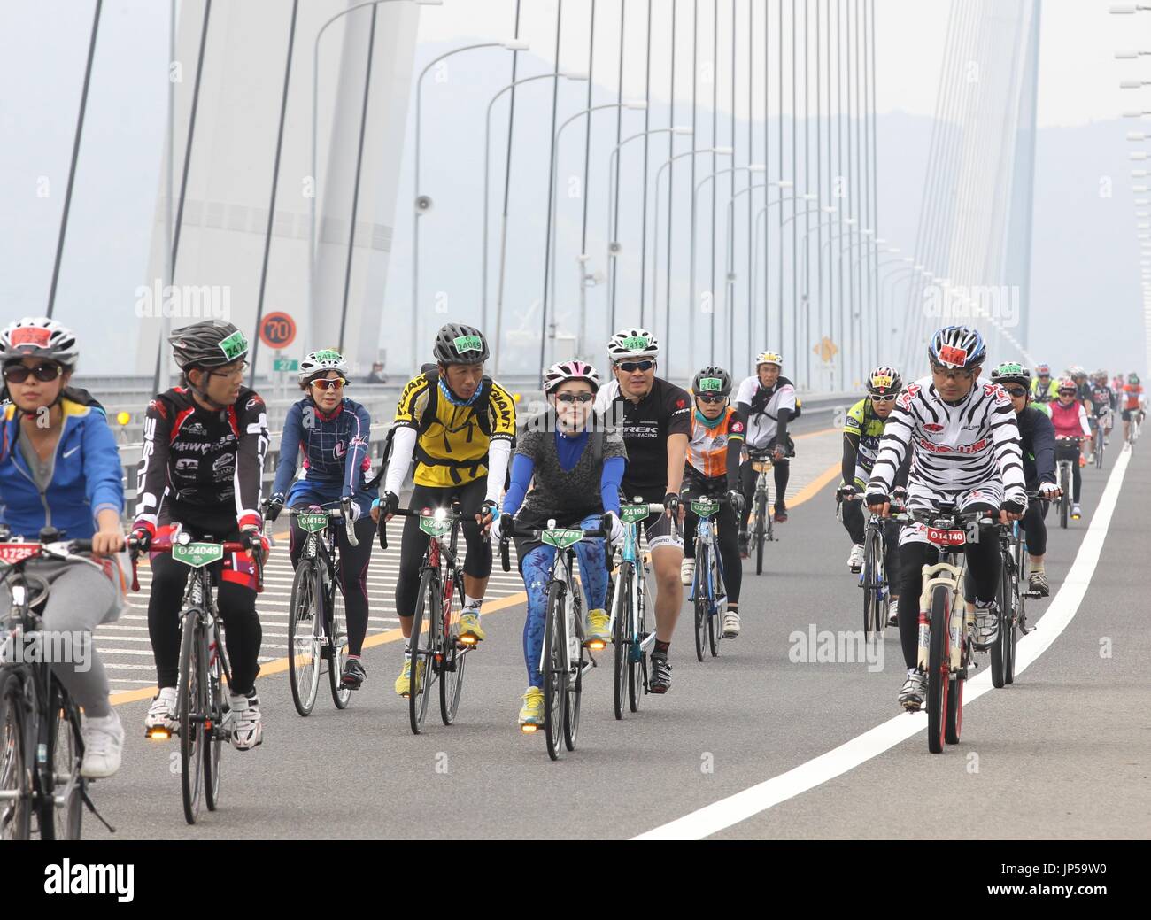 MATSUYAMA, Japan - Cyclists ride on the Tatara Bridge, part of the ...