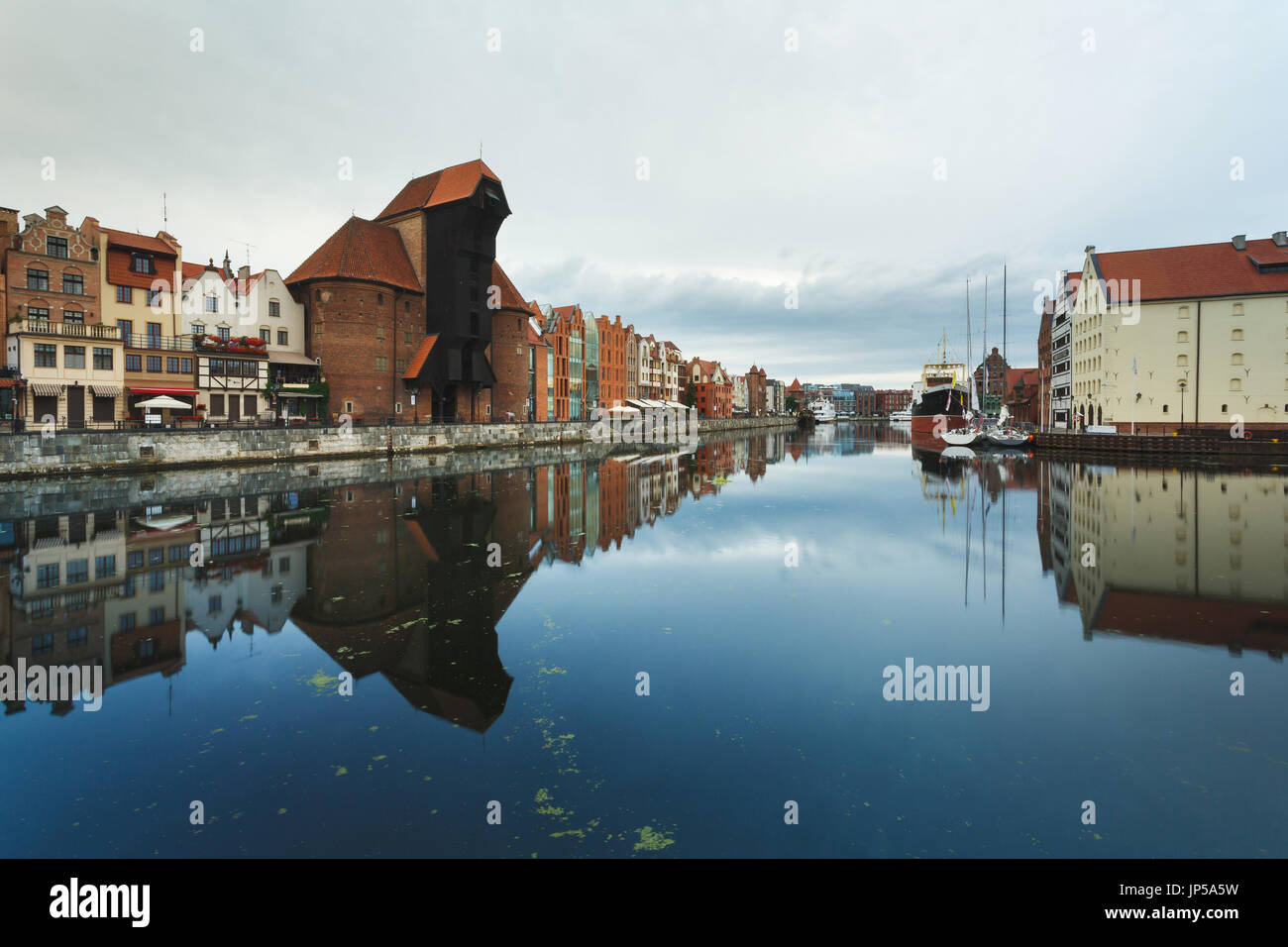 Buildings of the old town Gdansk reflected in a water in early morning ...