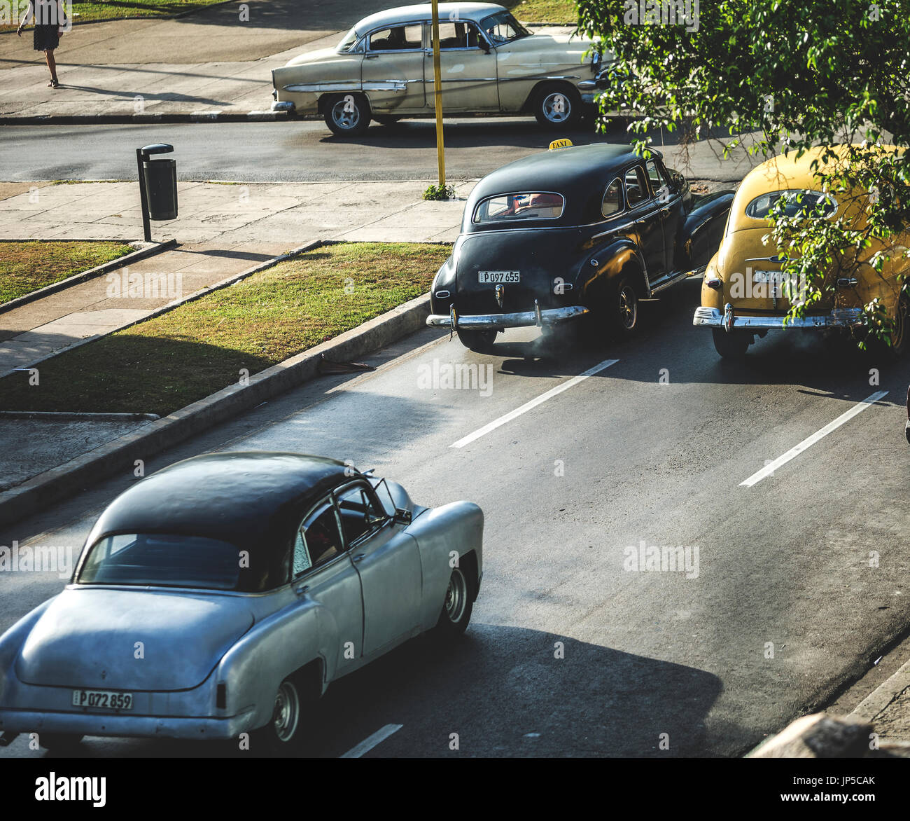 Classic 1950s cars driving on a road at a junction Stock Photo - Alamy