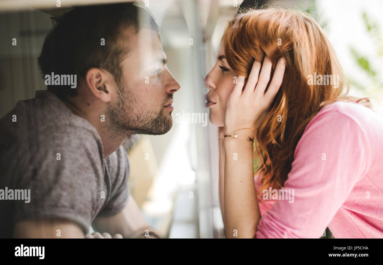 A couple kissing through a pane of glass of a window Stock Photo - Alamy