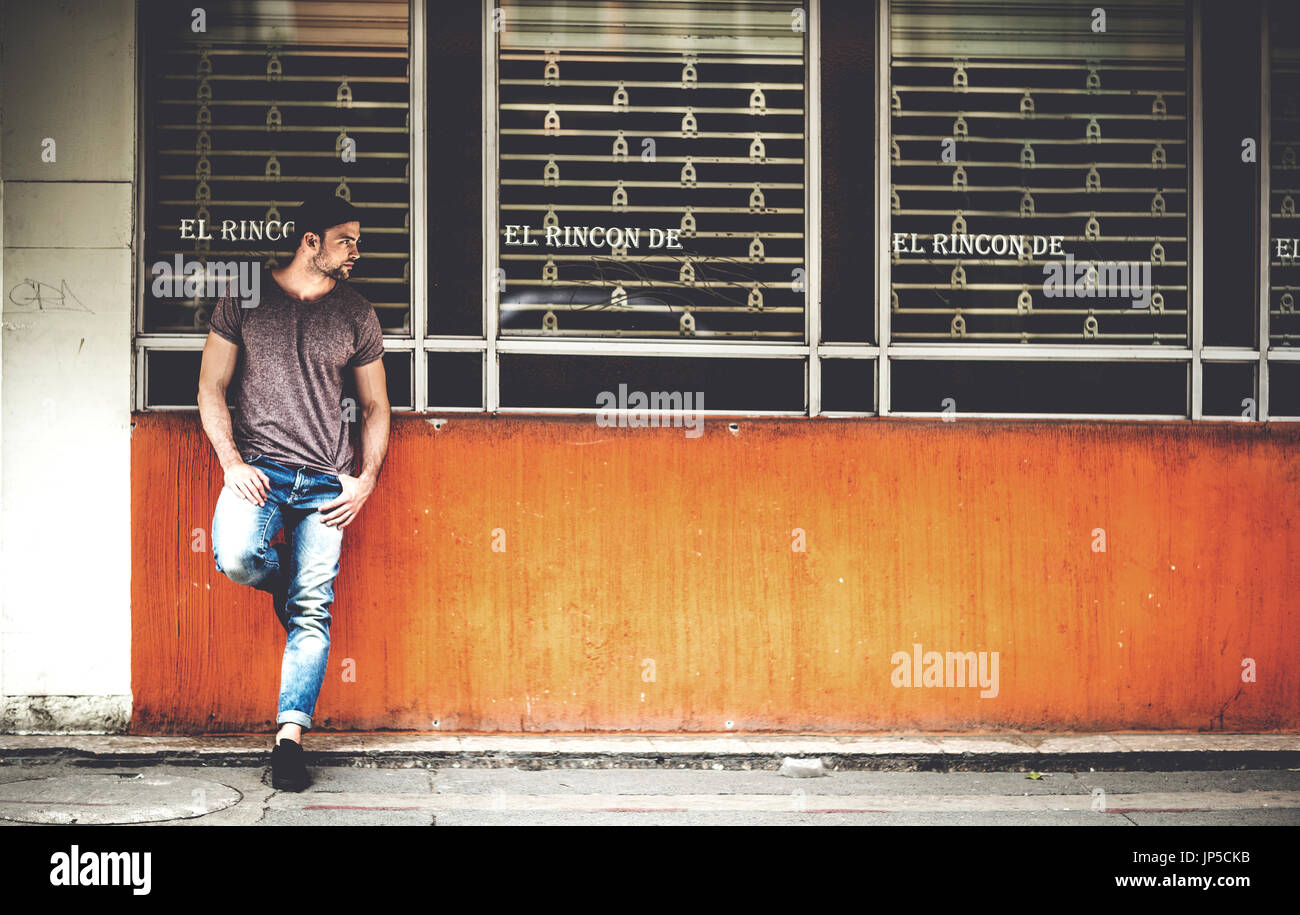 A man leaning against the storefront of a closed cafe Stock Photo - Alamy