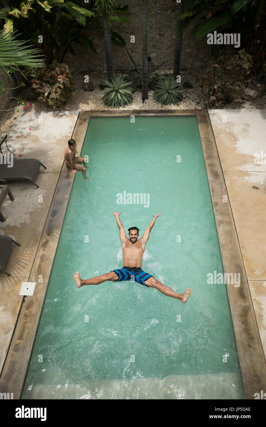 High angle shot of a man jumping backwards into a swimming pool Stock ...