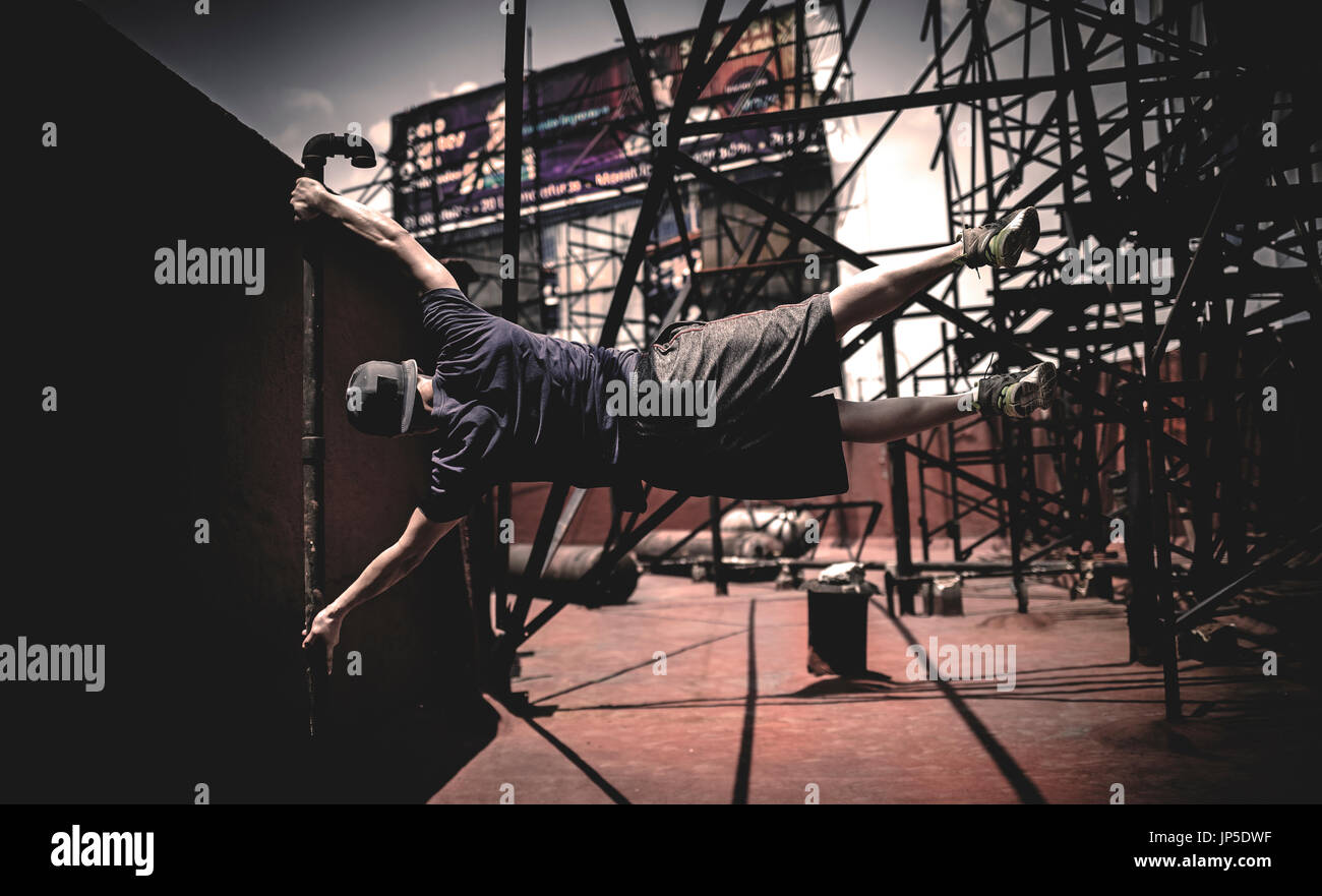A parcour runner swinging from a scaffolding pole Stock Photo - Alamy
