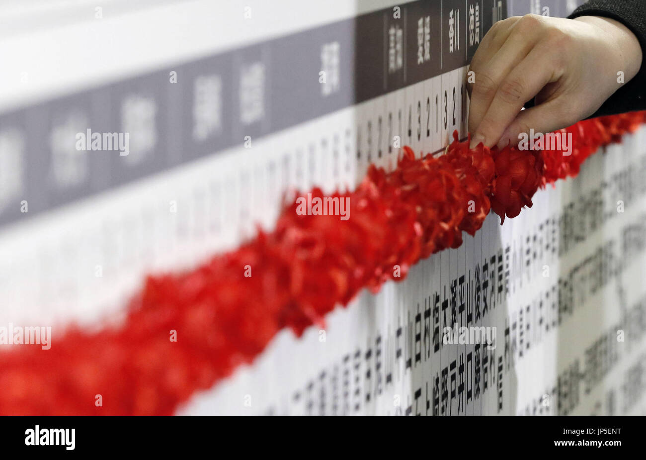 TOKYO, Japan - Red imitation roses, a marker for a successful candidate ...
