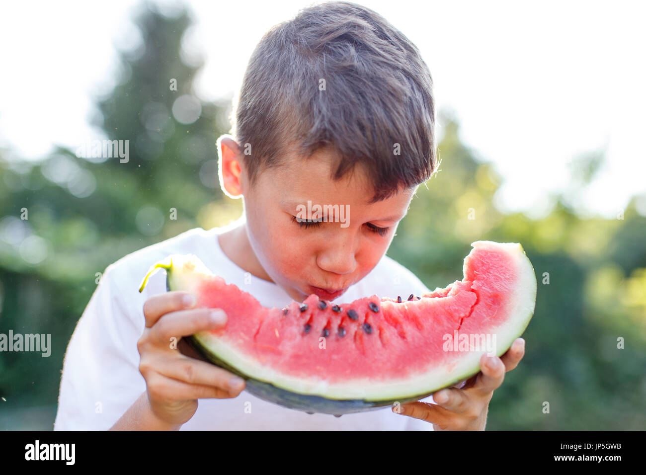 Little child bite into watermelon outdoor Stock Photo - Alamy