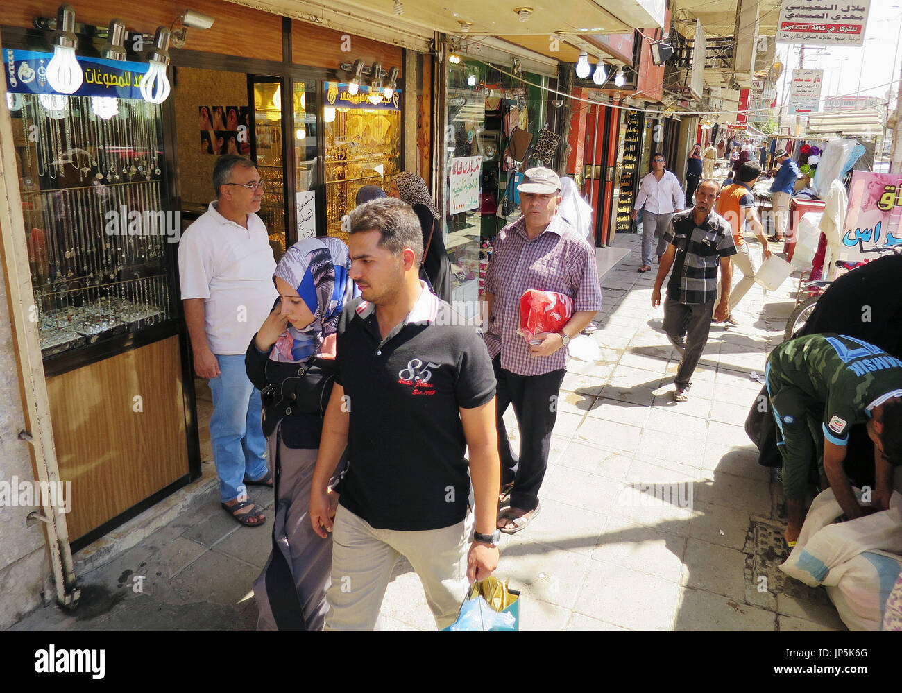 BAGHDAD, Iraq - Shoppers stroll on the streets of a shopping district ...