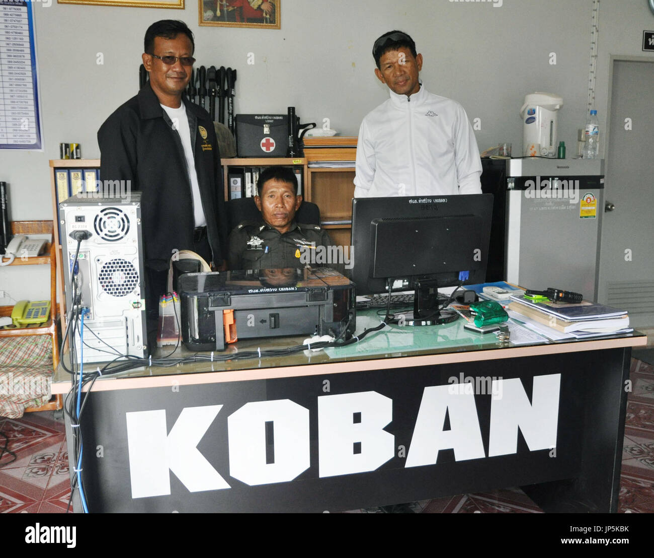 BANGKOK, Thailand - Three Thai policemen work at a "koban" small police ...