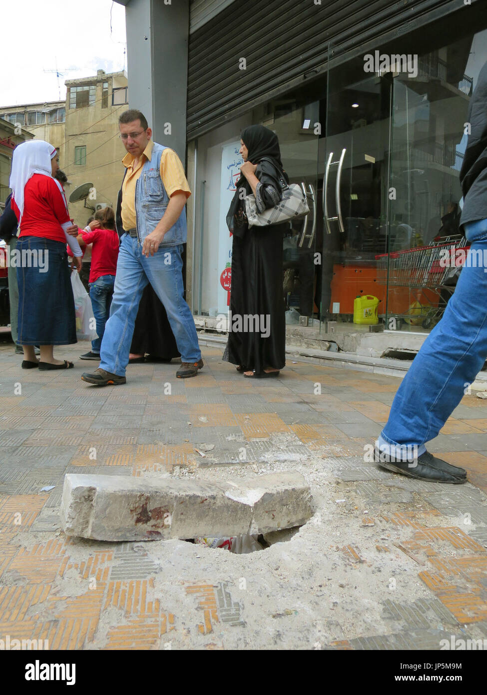 DAMASCUS, Syria - A hole created by mortar fire remains on a shopping ...