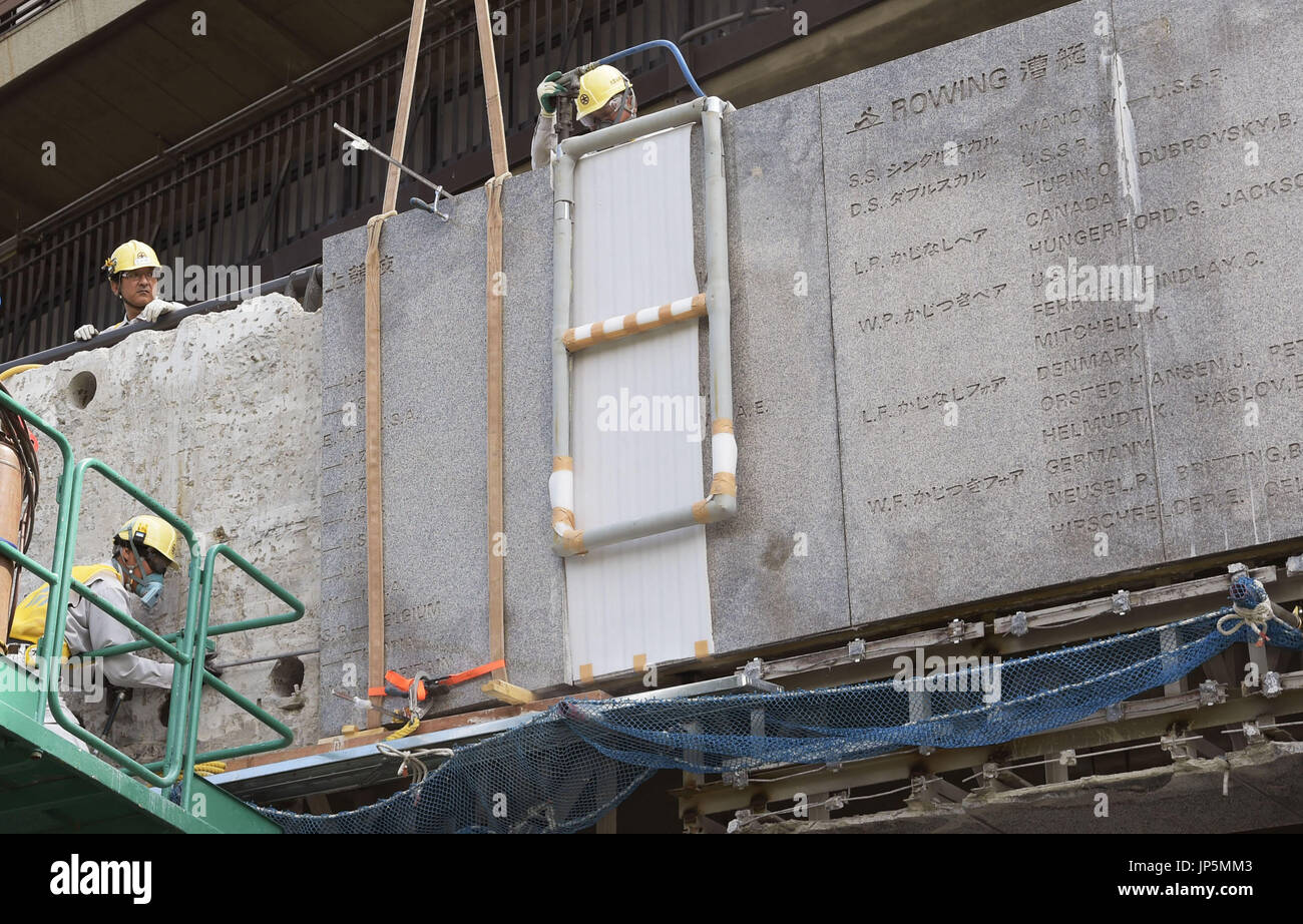 TOKYO, Japan - Workers detach granite slabs engraved with the names of ...