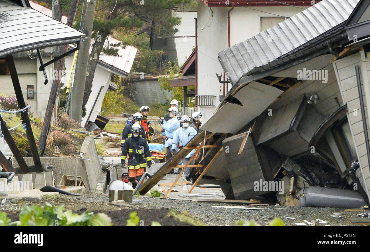 NAGANO, Japan - Firefighters and rescue workers walk among collapsed ...