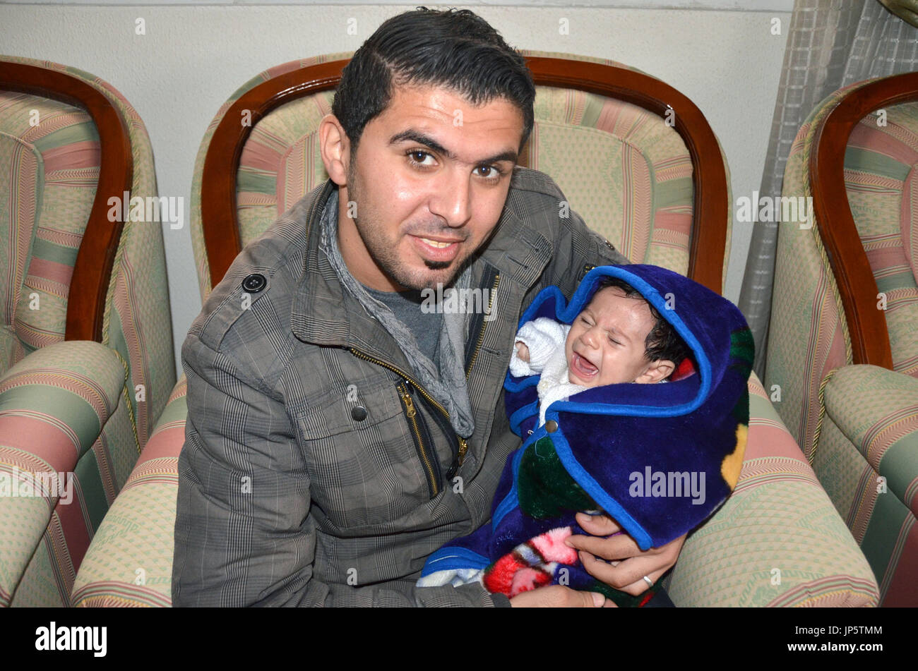 GAZA, Palestine Autonomous Area - A young Palestinian father holds his ...