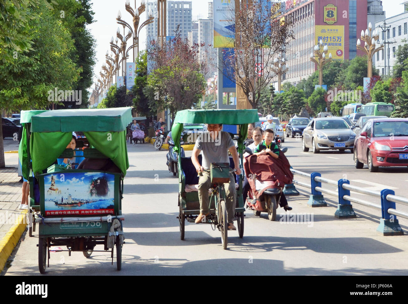LESHAN, China - Cycle rickshaws run along a street in Leshan, China, in ...