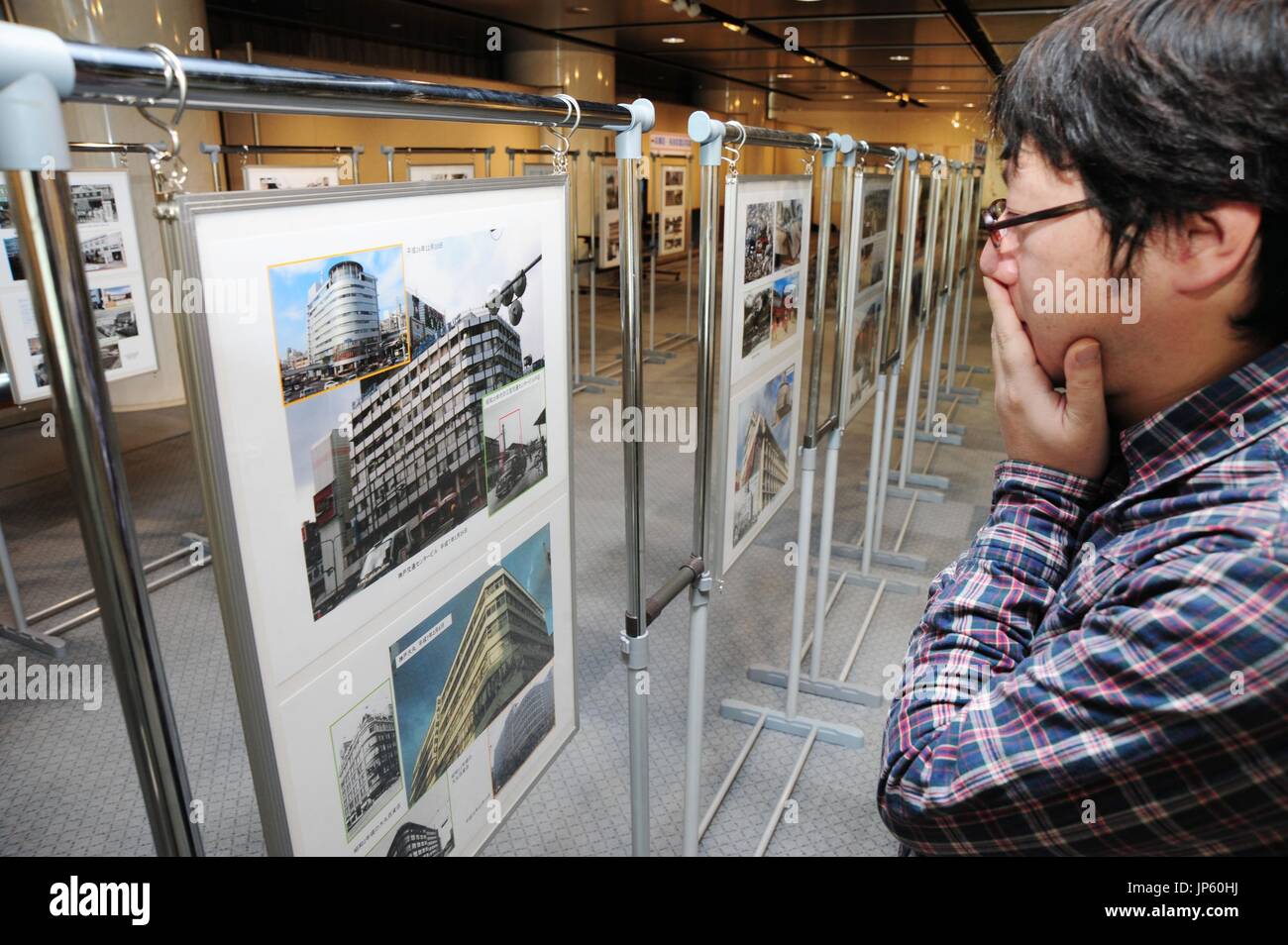 KOBE, Japan - A man looks at photos showing destruction in Kobe ...