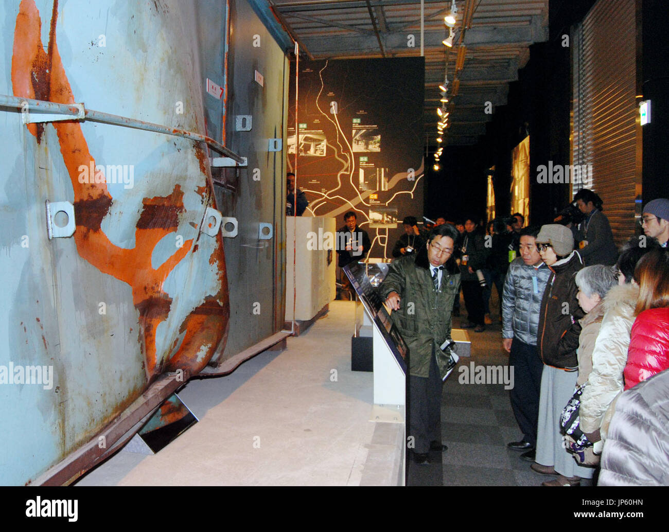 OSAKA, Japan - Visitors listen to a guide explain about a twisted steel ...