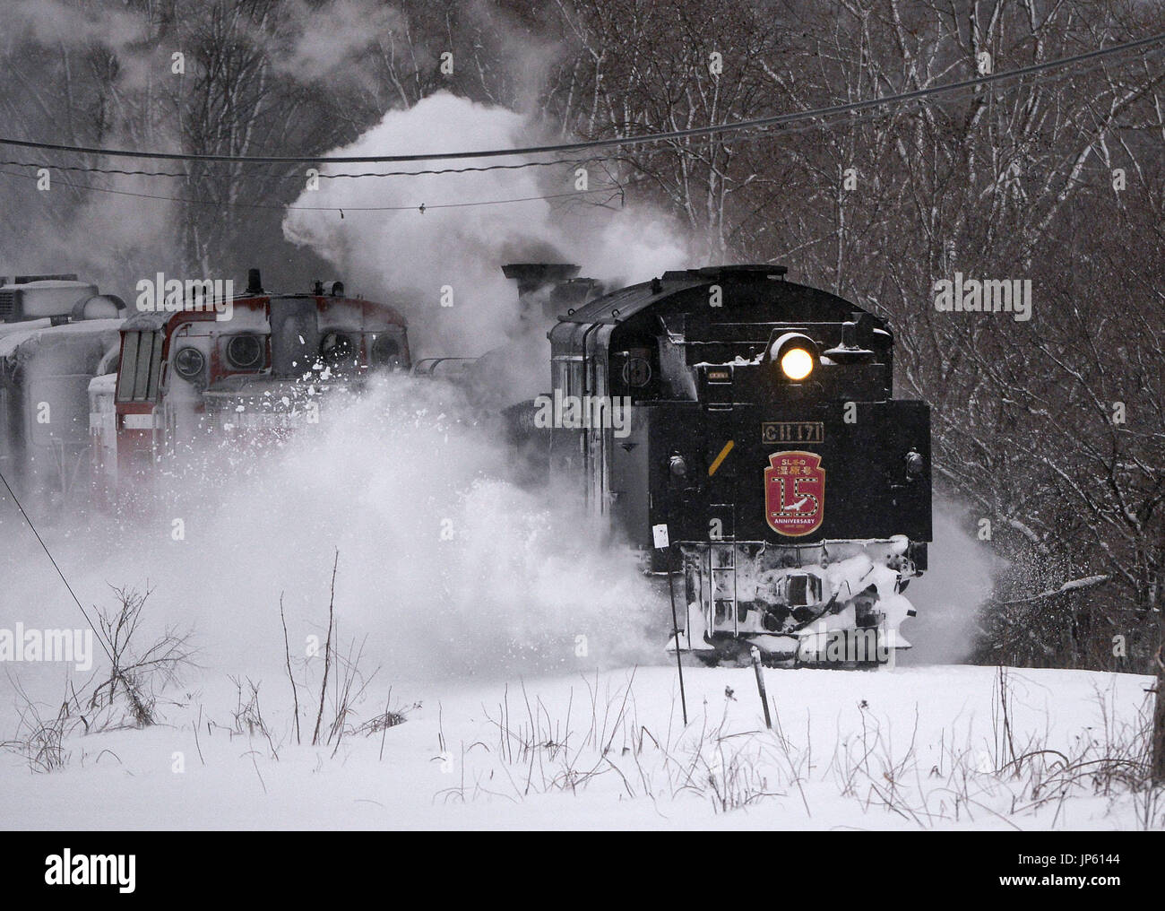 A steam locomotive-led train runs in the snow-covered Kushiro Shitsugen ...