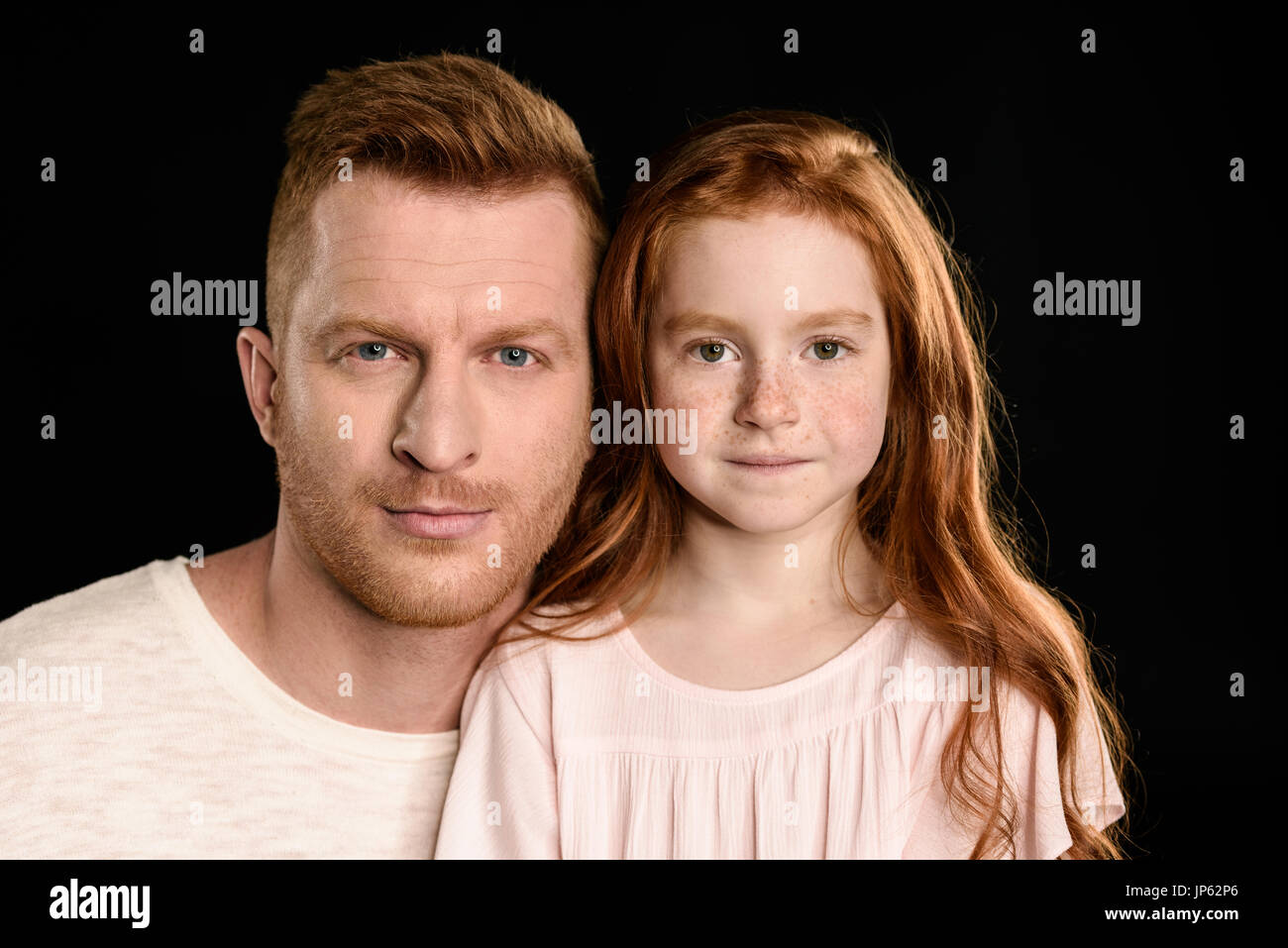 redhead father and adorable daughter looking at camera isolated on ...