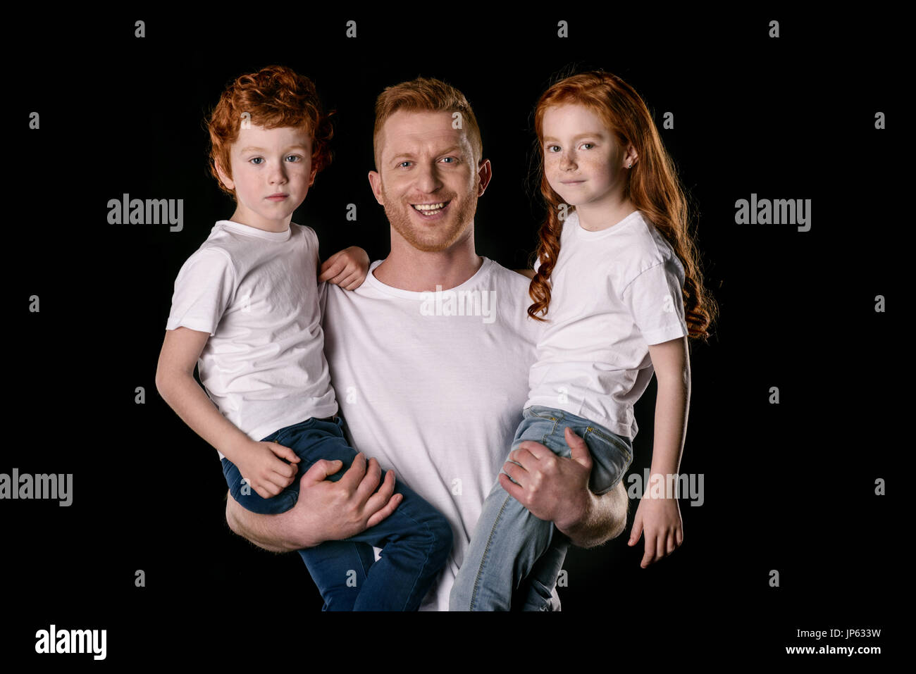 Happy father carrying adorable little children isolated on black Stock ...
