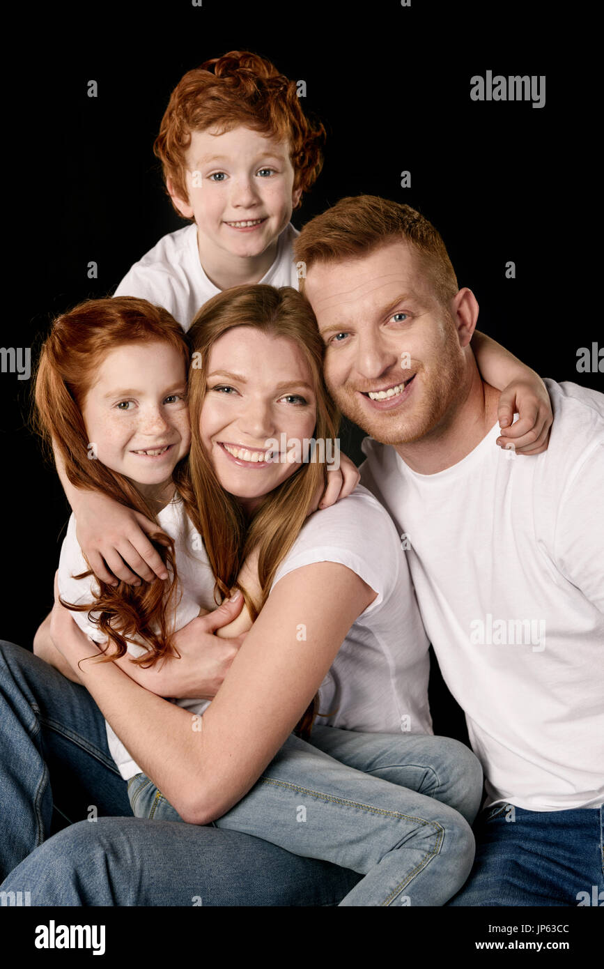 portrait of happy family hugging each other isolated on black Stock ...
