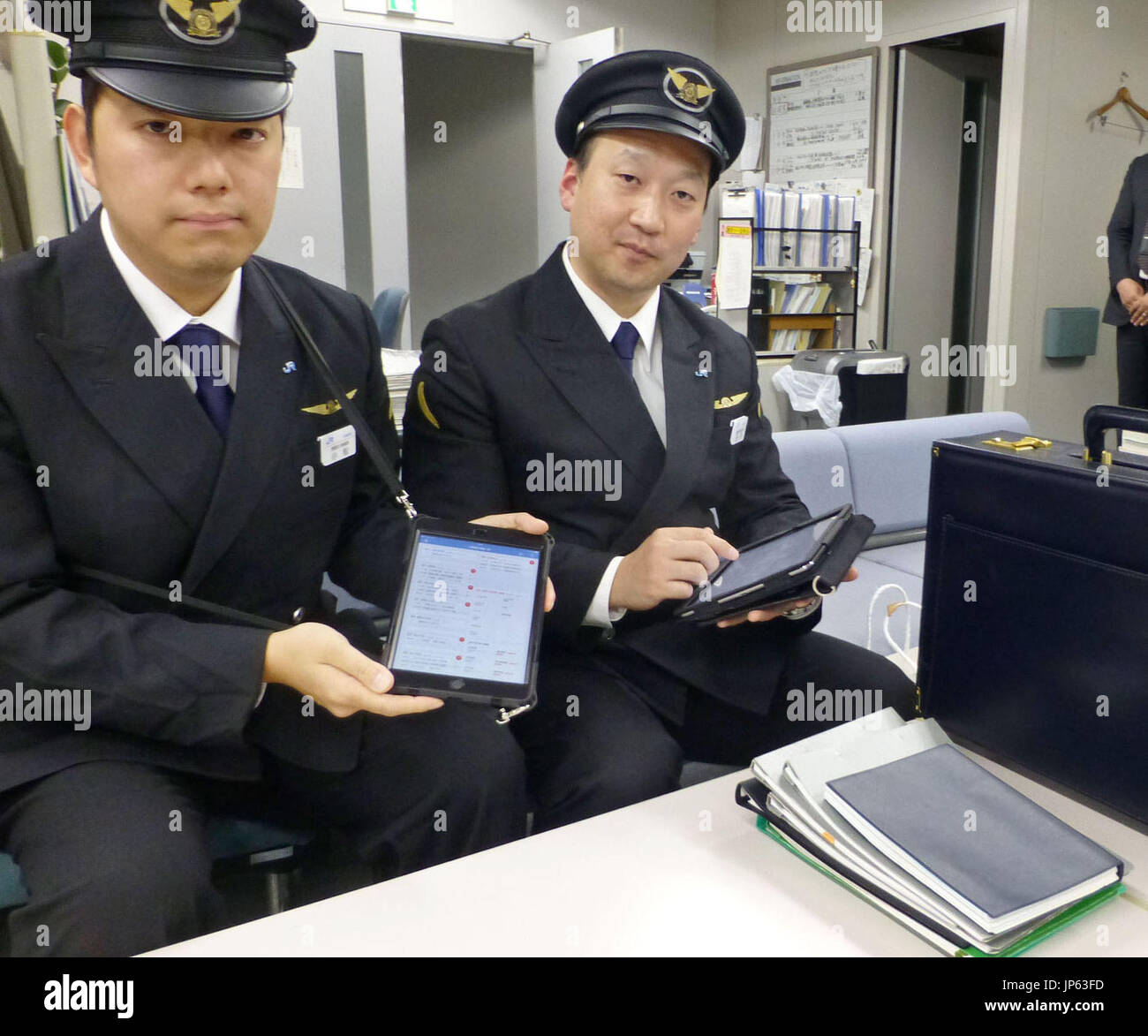 OSAKA, Japan - A Shinkansen bullet train crew carries iPad tablet ...