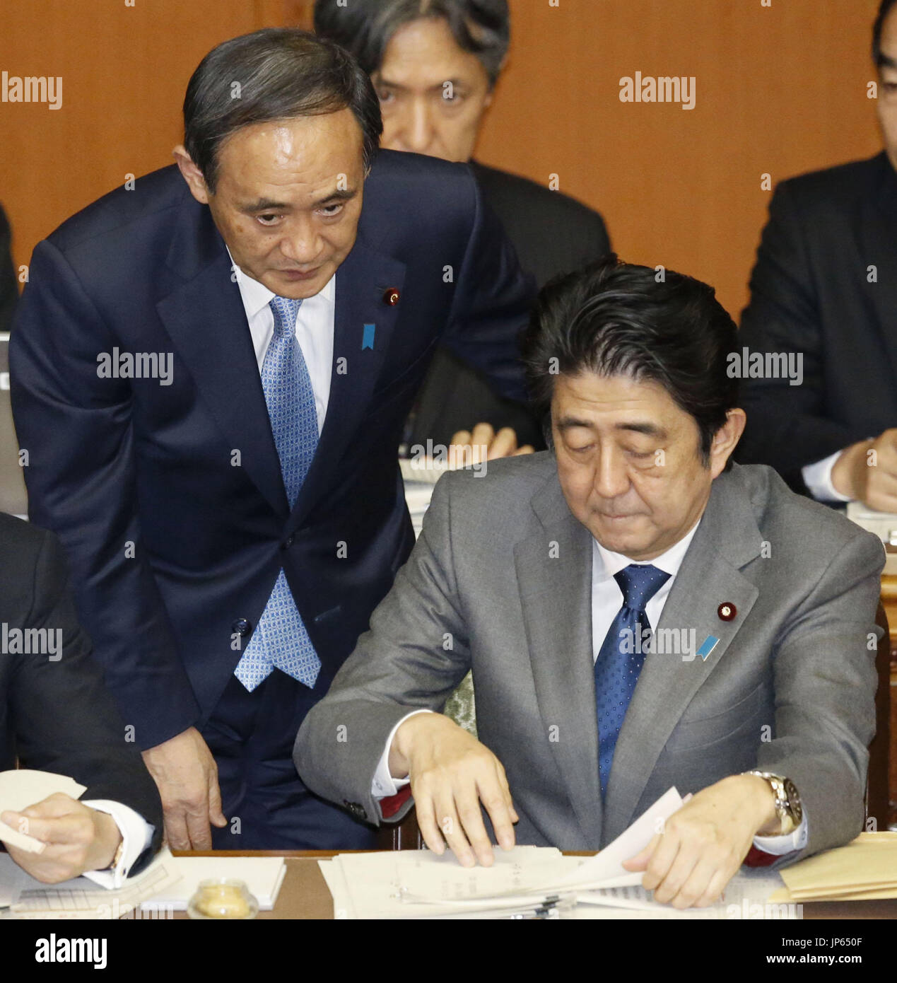 Chief Cabinet Secretary Yoshihide Suga (L) speaks to Prime Minister ...