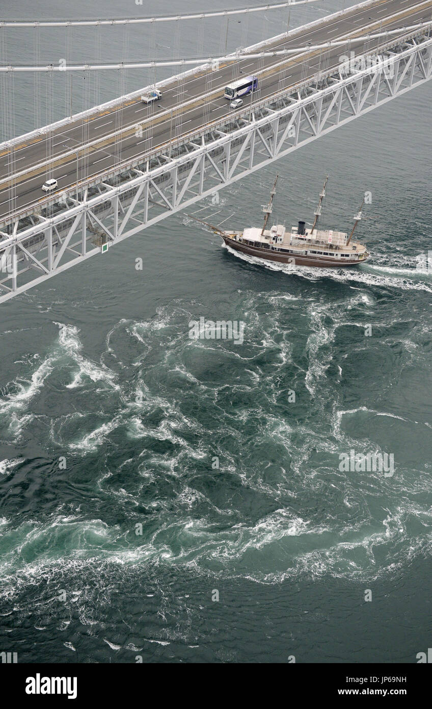 A passenger ship sails by whirling waves in the Naruto Strait off ...