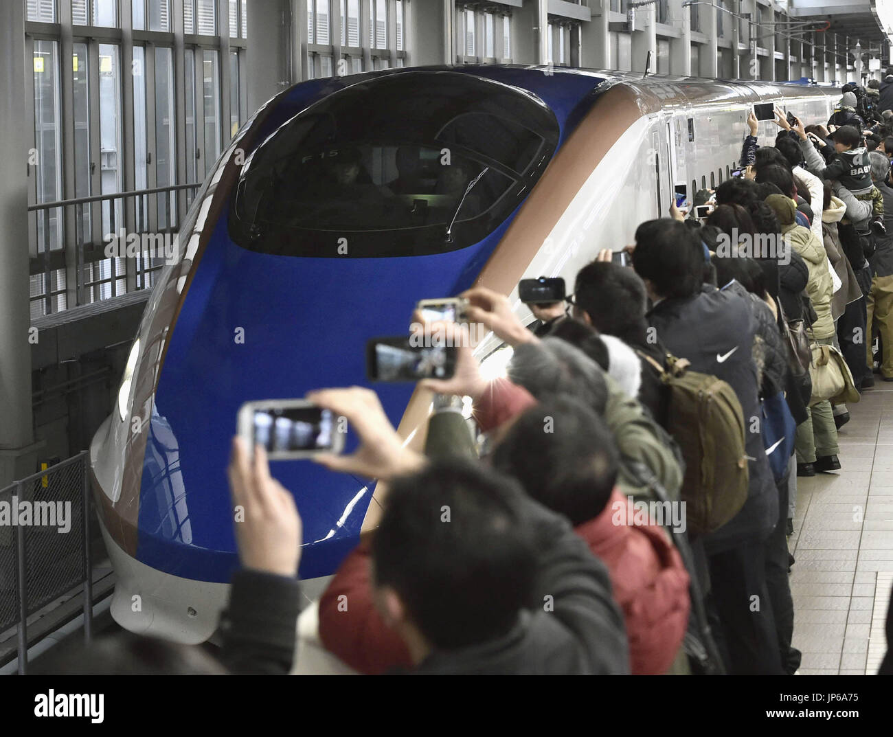 People take photos of the first bullet train from Tokyo on the Hokuriku ...