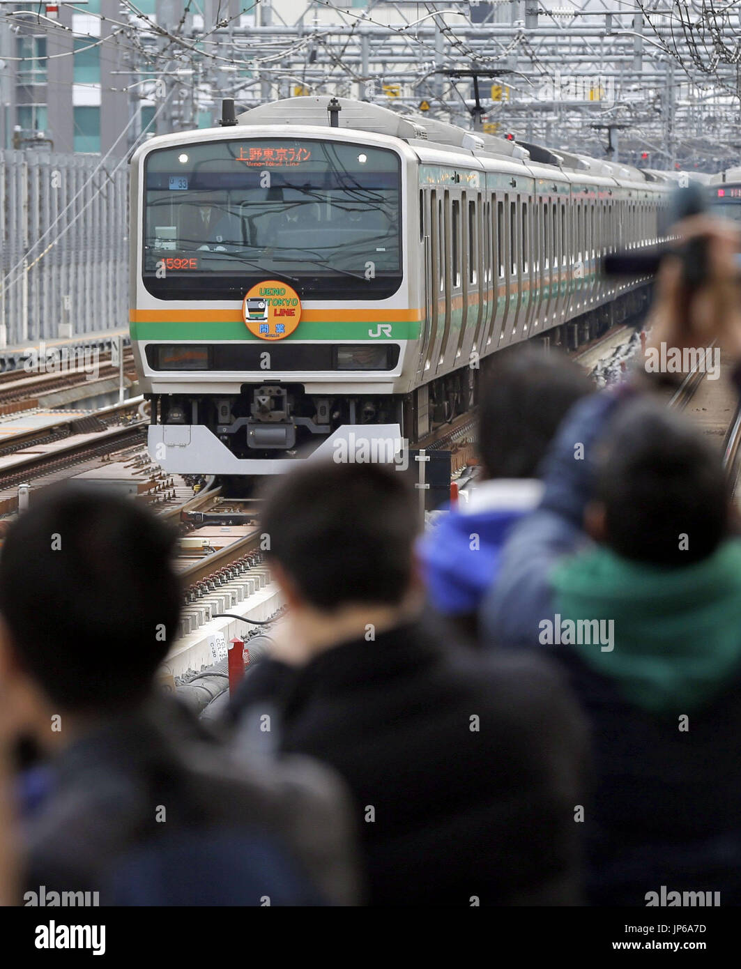 Railway fans await an incoming train on the Ueno Tokyo Line at JR ...