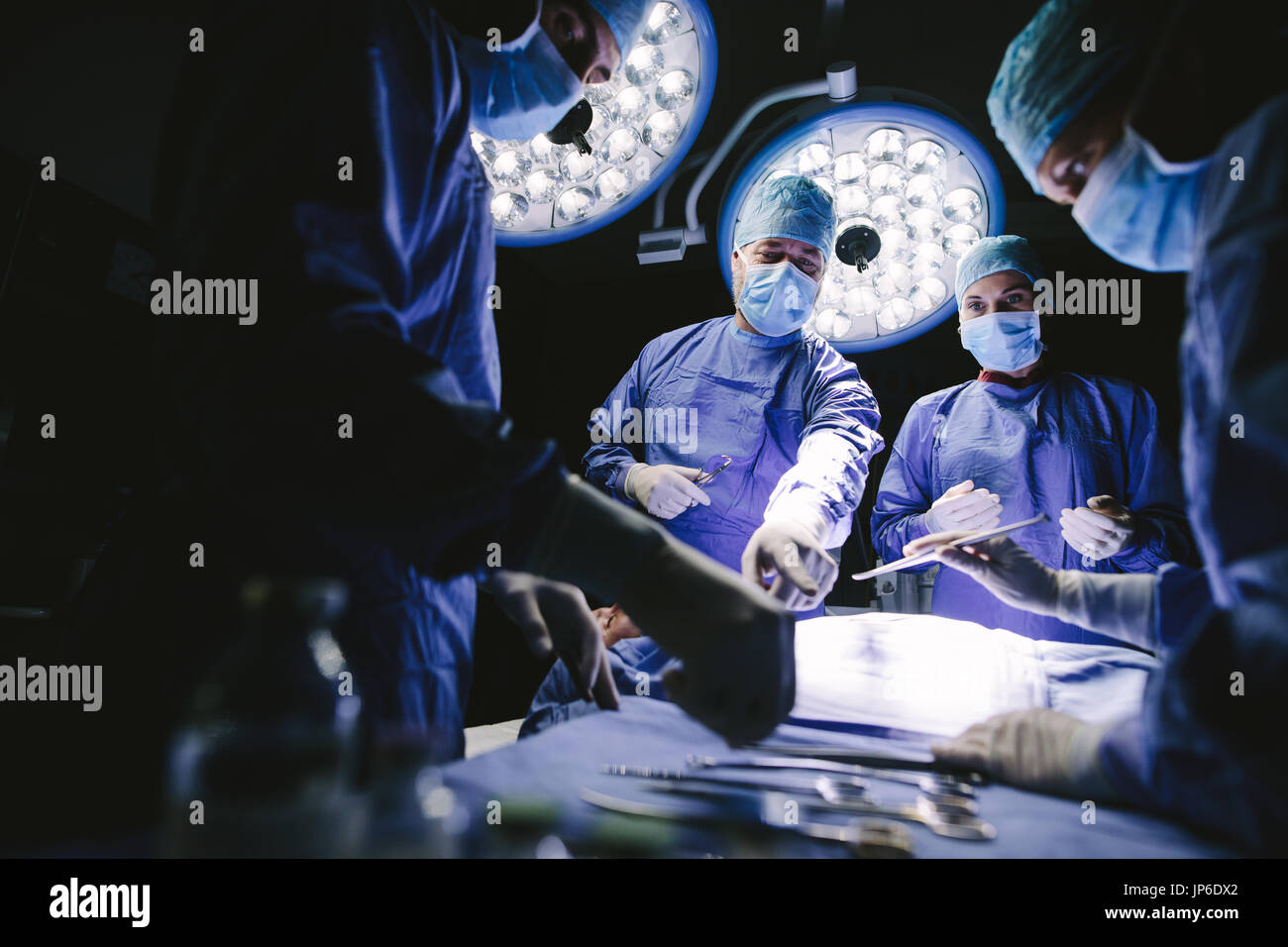 Group of surgeons in operating theater. Medical team performing surgery ...
