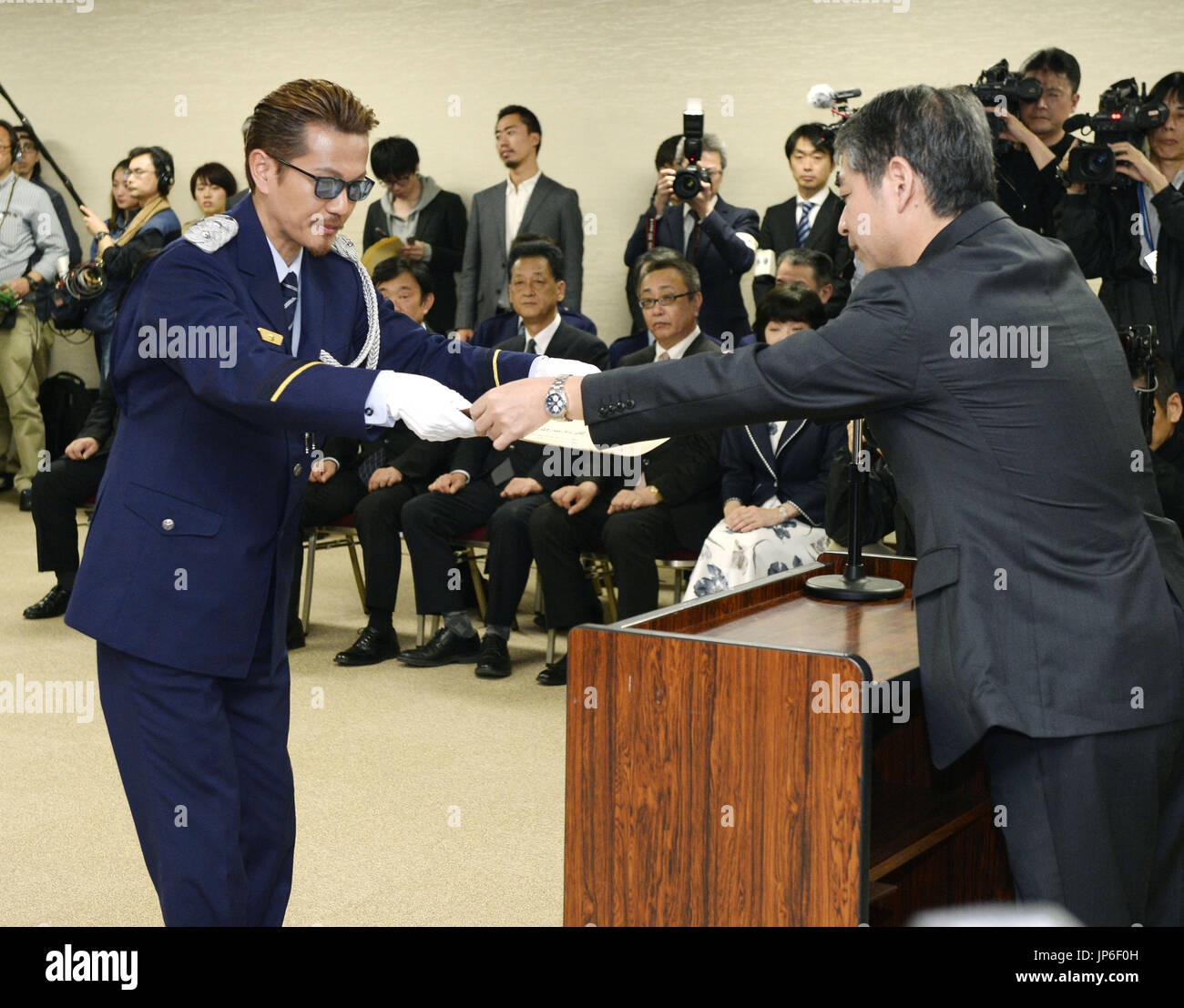 Atsushi Sato (L) of pop group Exile receives a letter of assignment to support the ...