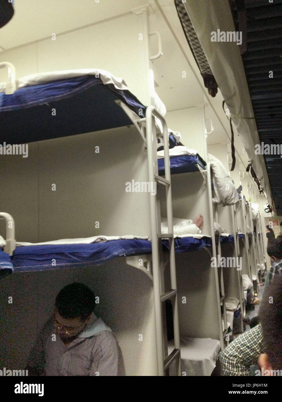 Travelers rest on bunk beds aboard a sleeper train in China as seen in ...