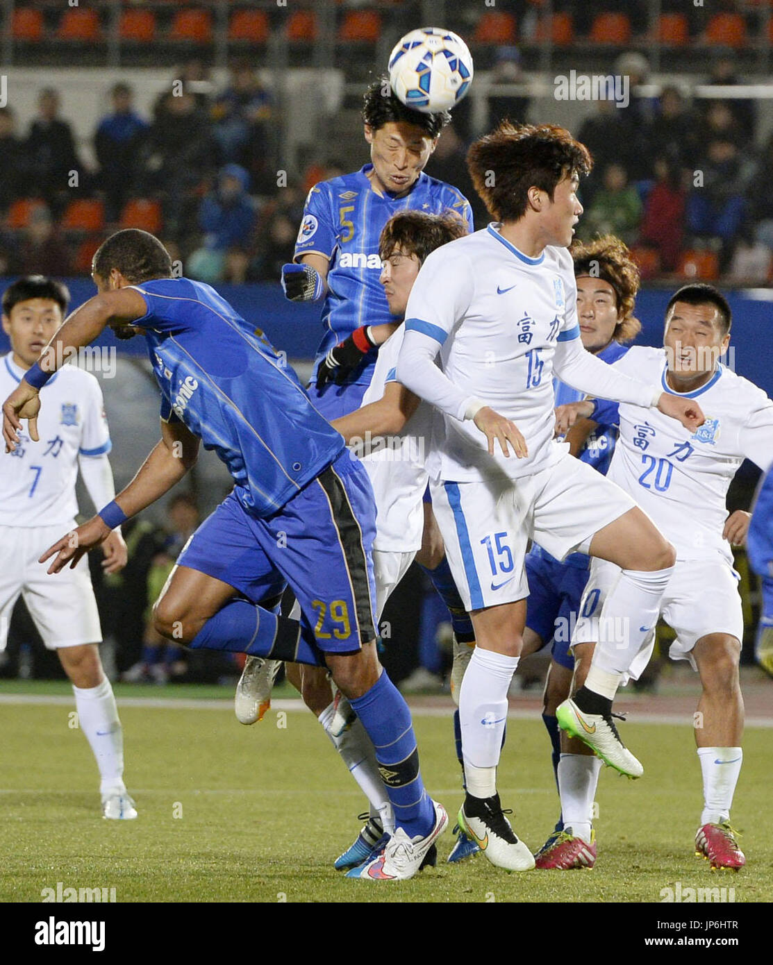 Defender Daiki Niwa (C) of Japanese side Gamba Osaka attempts a header ...