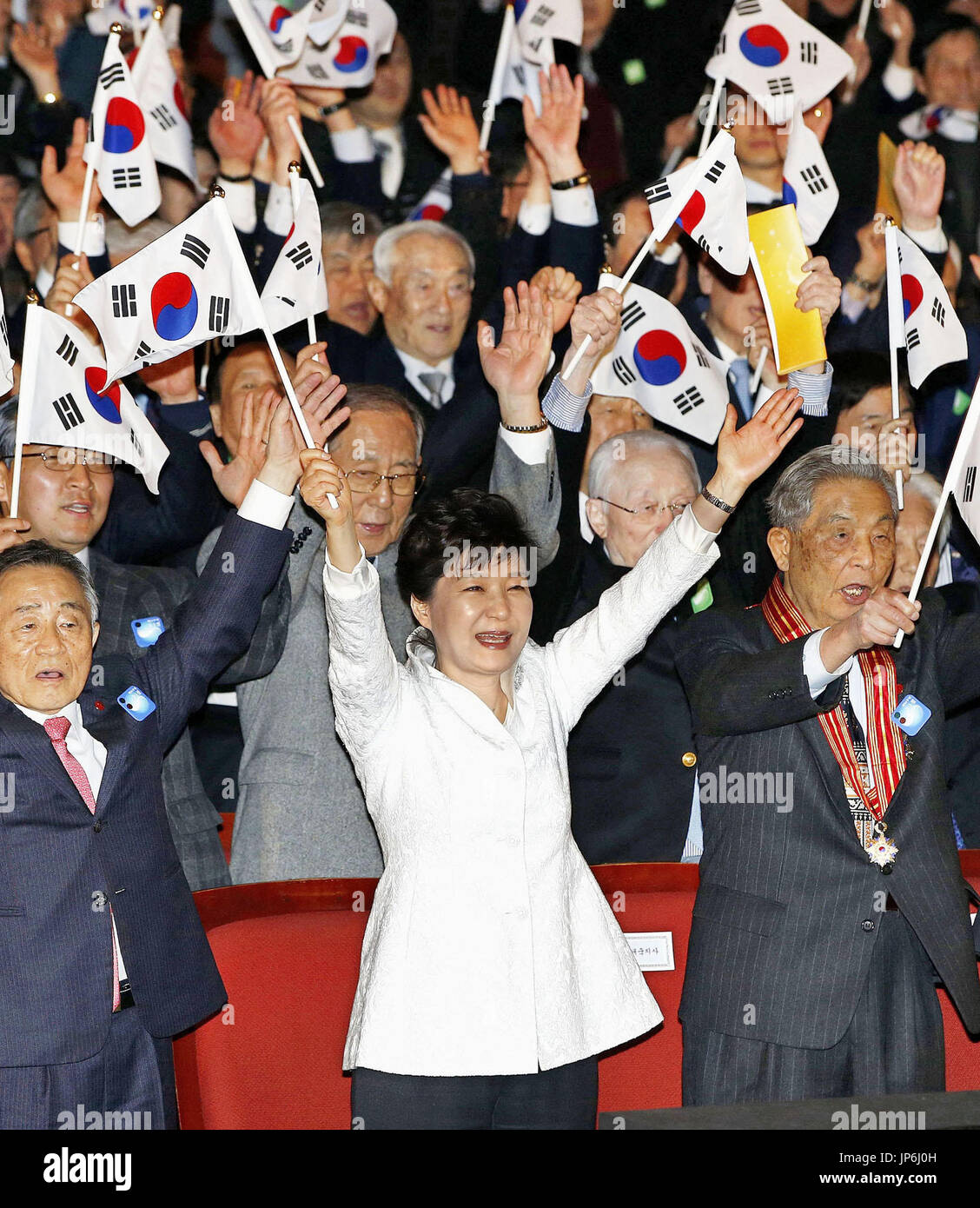 South Korean President Park Geun Hye (C in front) holds up a national ...