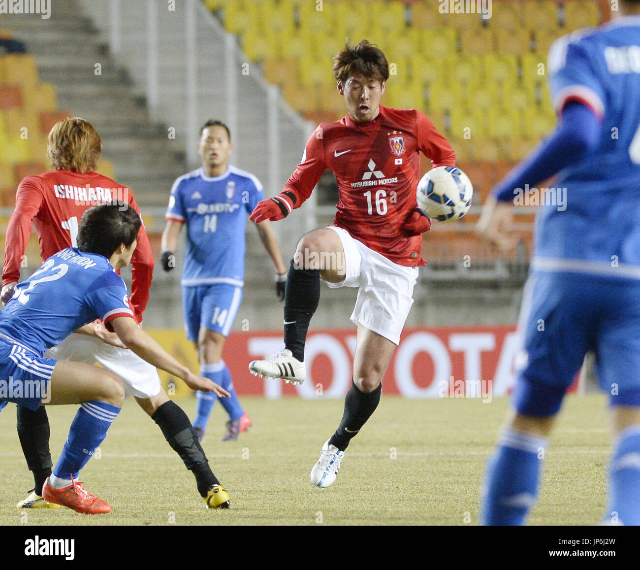 Takuya Aoki (C) of Japanese side Urawa Red Diamonds makes a pass in the ...