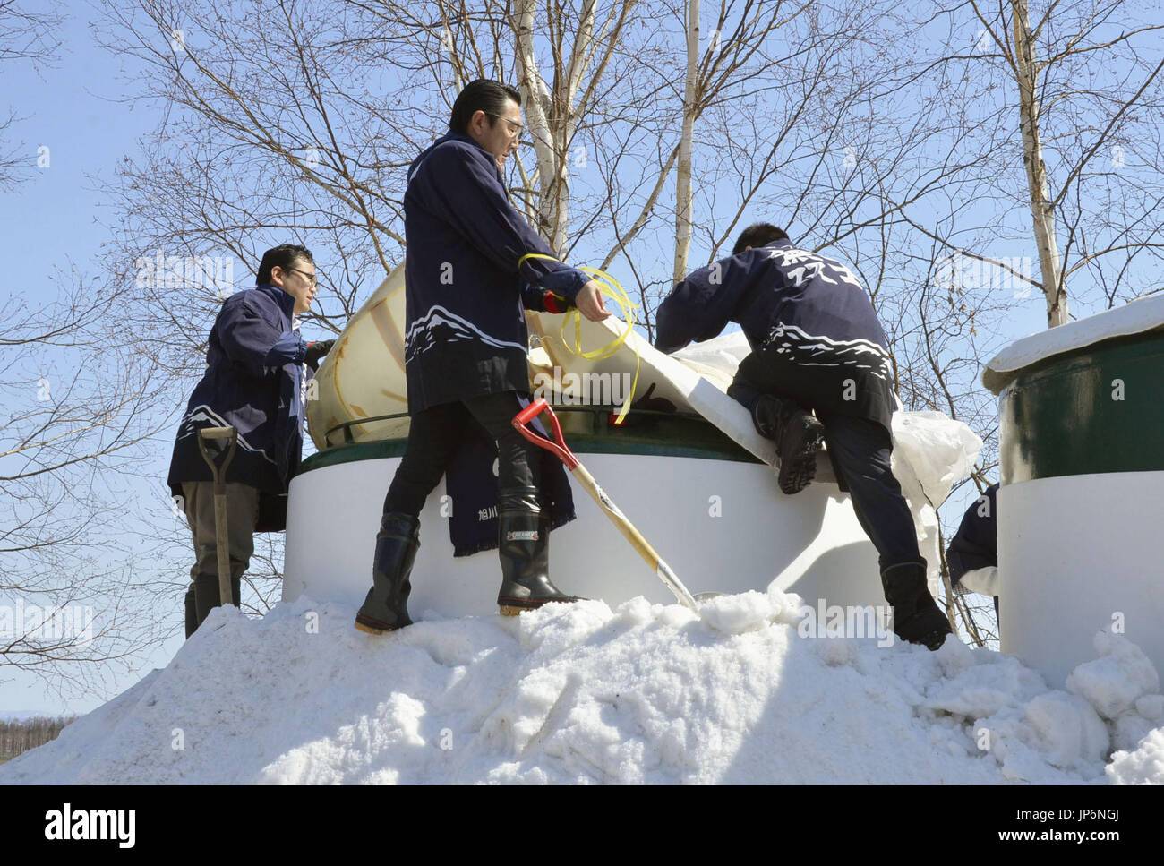 Sake brewers of Takasagoshuzo Inc. open the lid of a container after ...