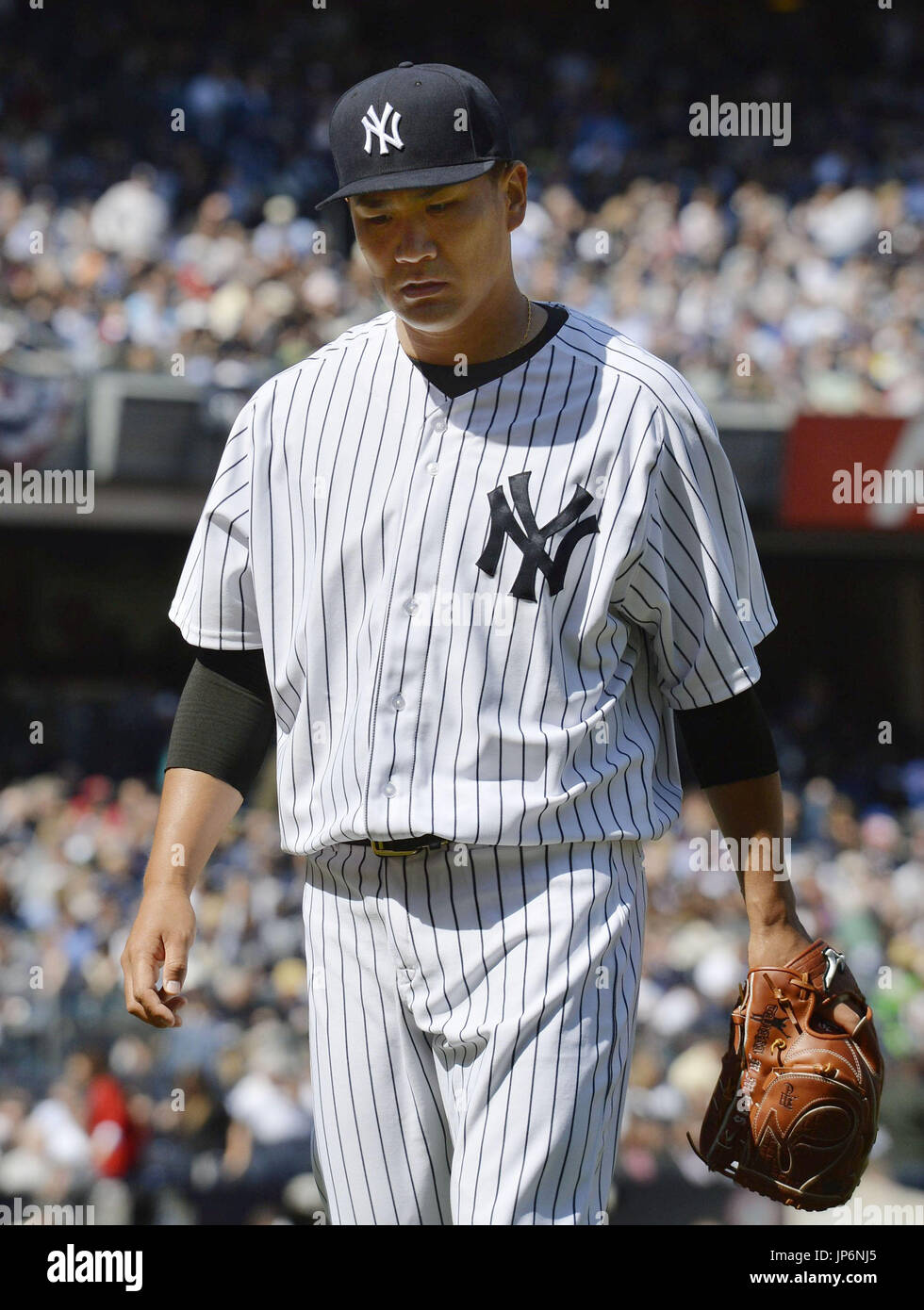 New York Yankees starter Masahiro Tanaka returns to the bench after completing pitching in the ...