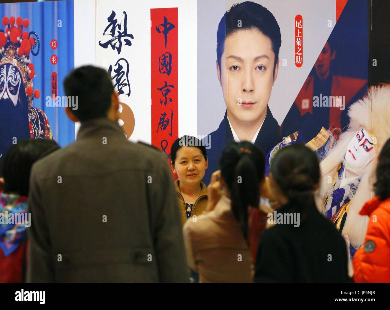 A female theatergoer gets her picture taken in front of a poster of ...