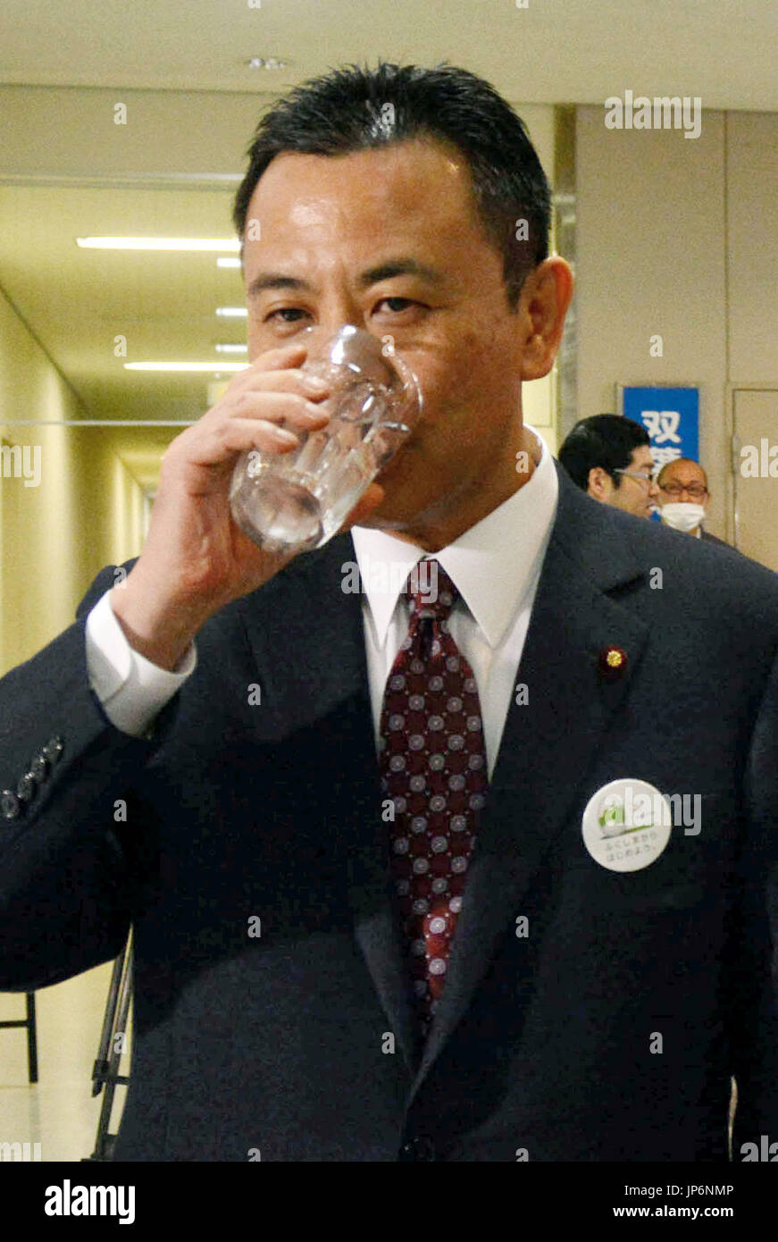 Yosuke Takagi, state minister of economy, trade and industry, drinks a glass of water treated at ...