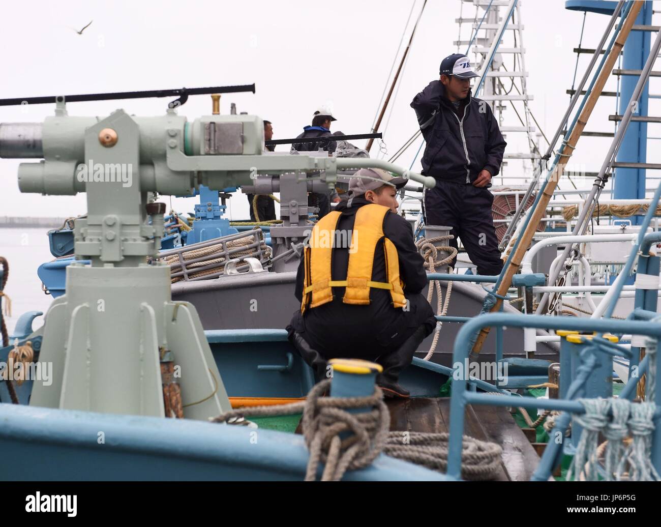 Crew members on a whaling ship prepare for departure from Ayukawa port ...