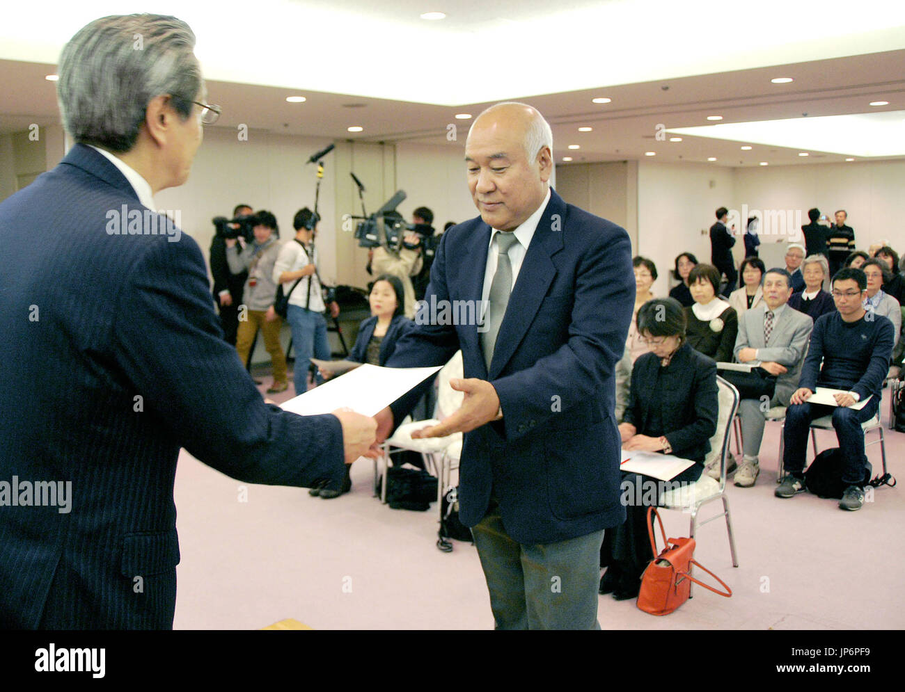 A man (front R) receives an official certificate in Hiroshima, western ...