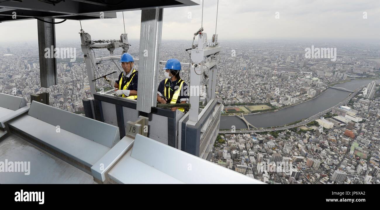 Window cleaners in a gondola are seen ascending to the upper ...