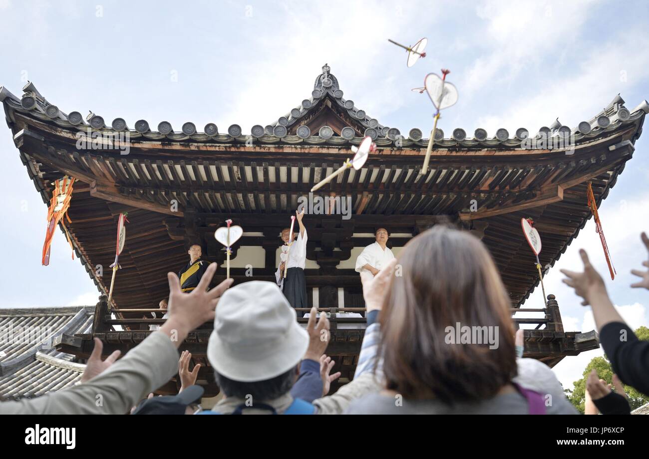 People try to catch heart-shaped fans thrown by Buddhist monks from the ...