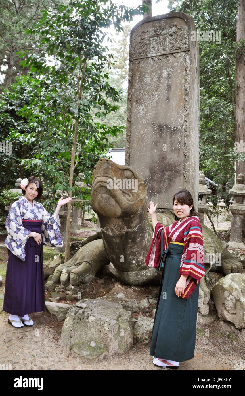 Female storytellers in traditional Japanese "hakama" costumes point to ...