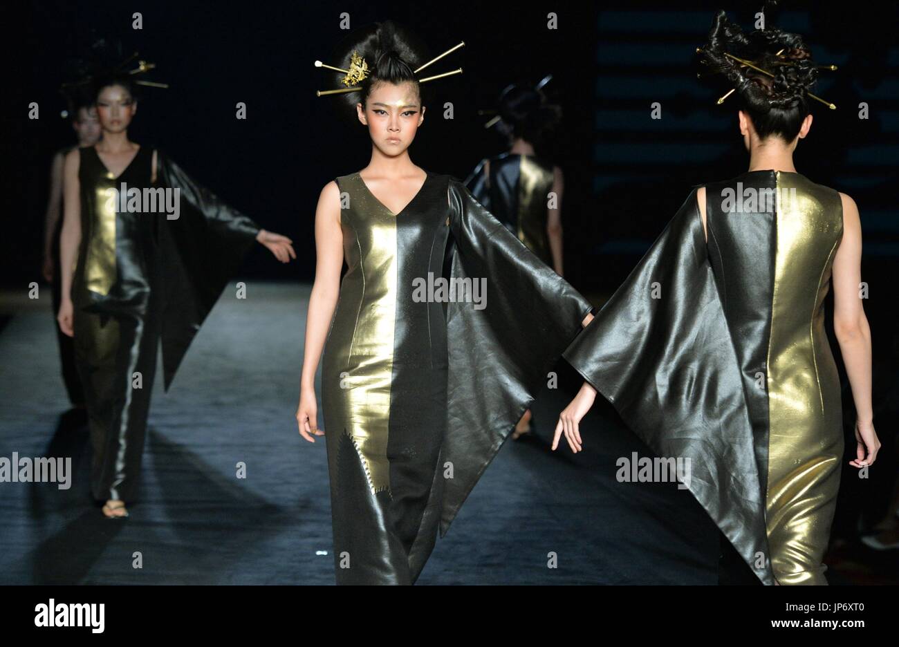 Chinese student models showcase a series of black and gold shiny ...