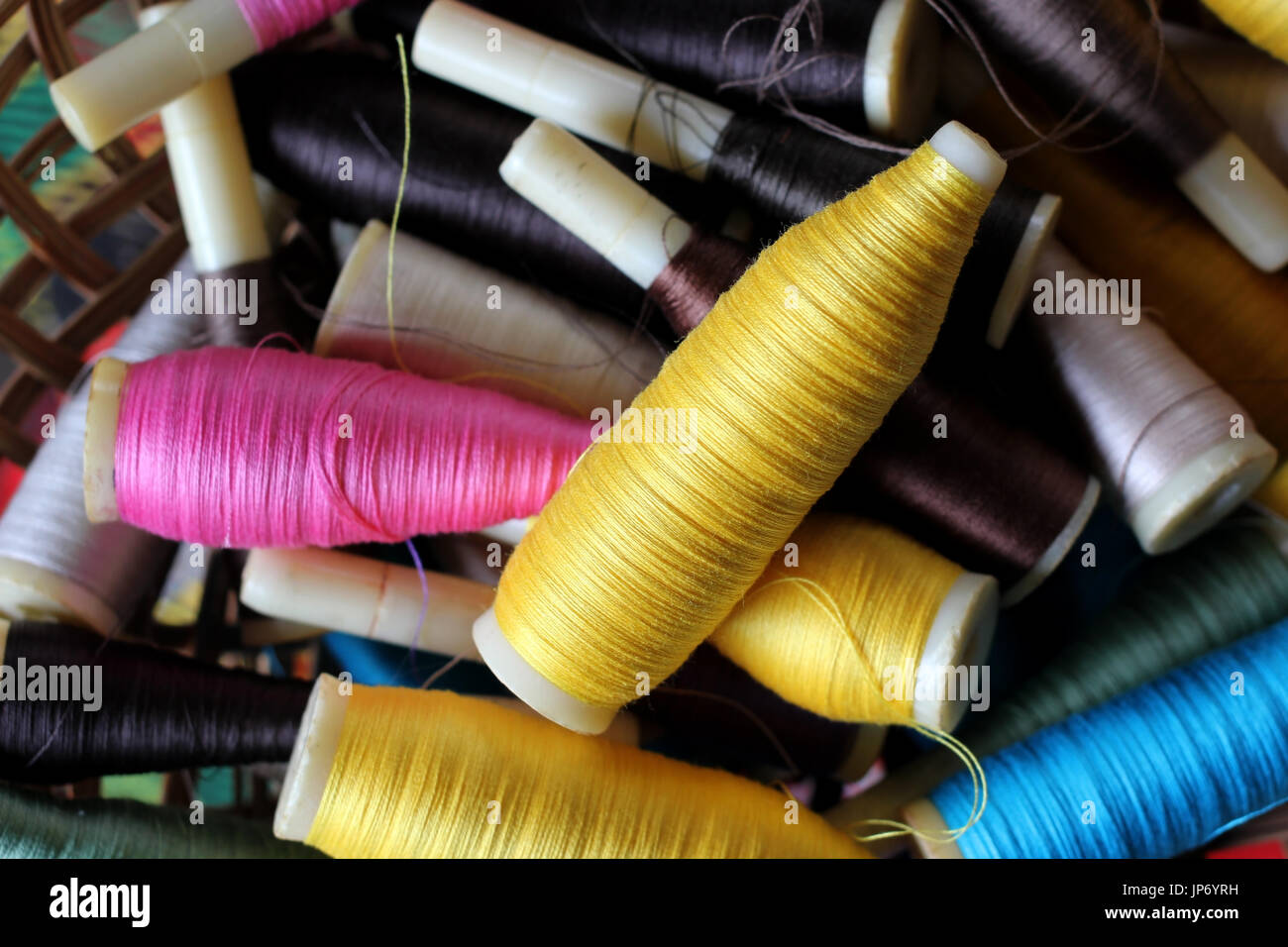 colorful bobbins of thread in basket Stock Photo - Alamy