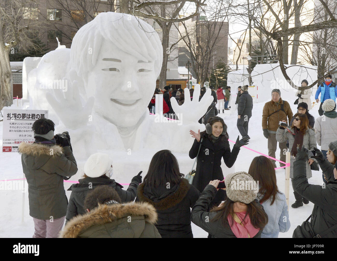 Visitors take pictures of a snow statue of Japanese figure skater ...