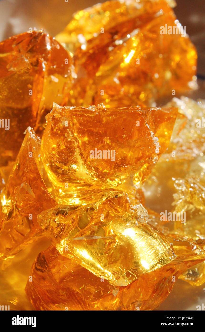 Pieces of golden caramel through which sunlight penetrates Stock Photo ...