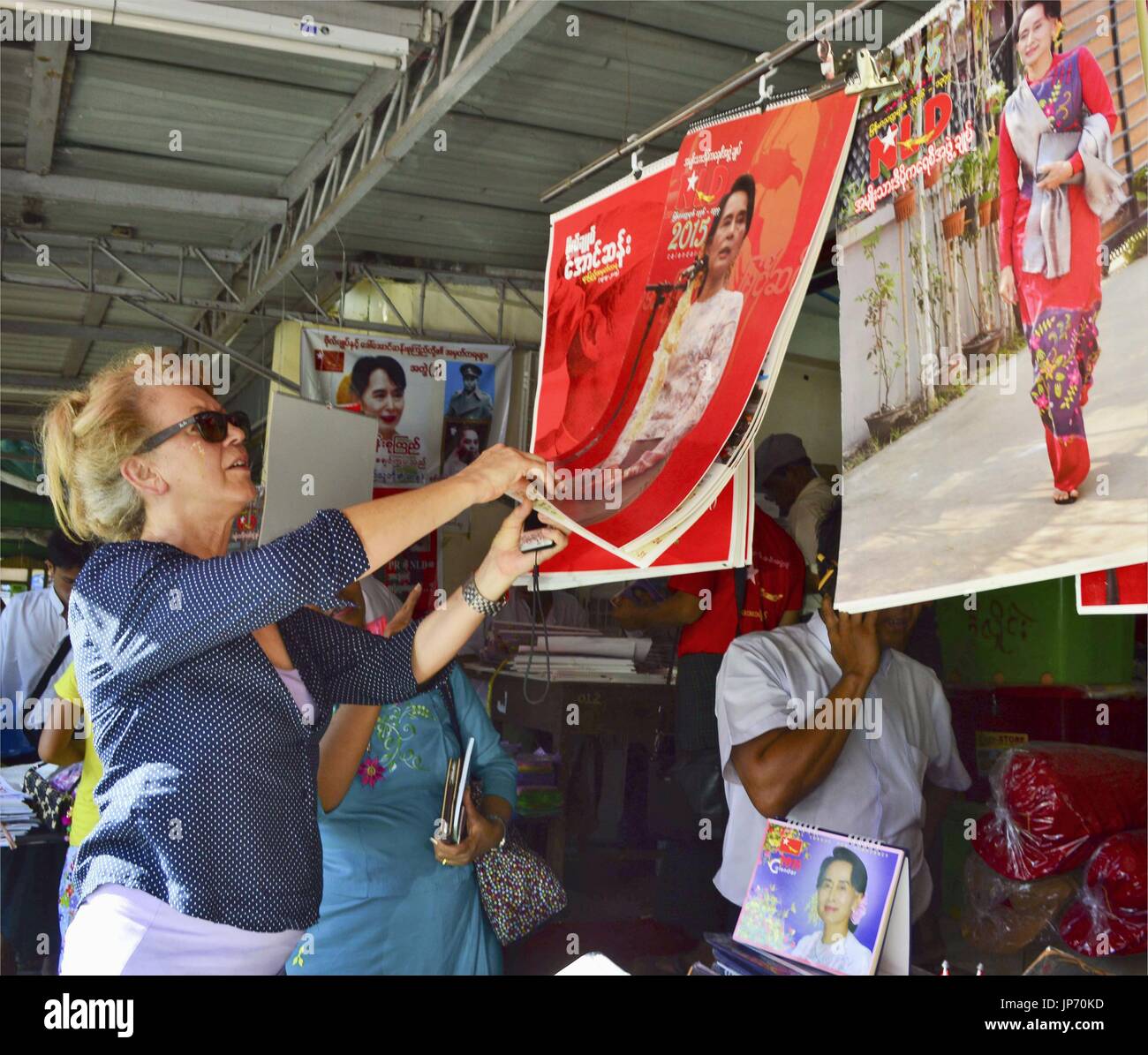 A tourist from Australia browses posters of Myanmar democratic leader ...