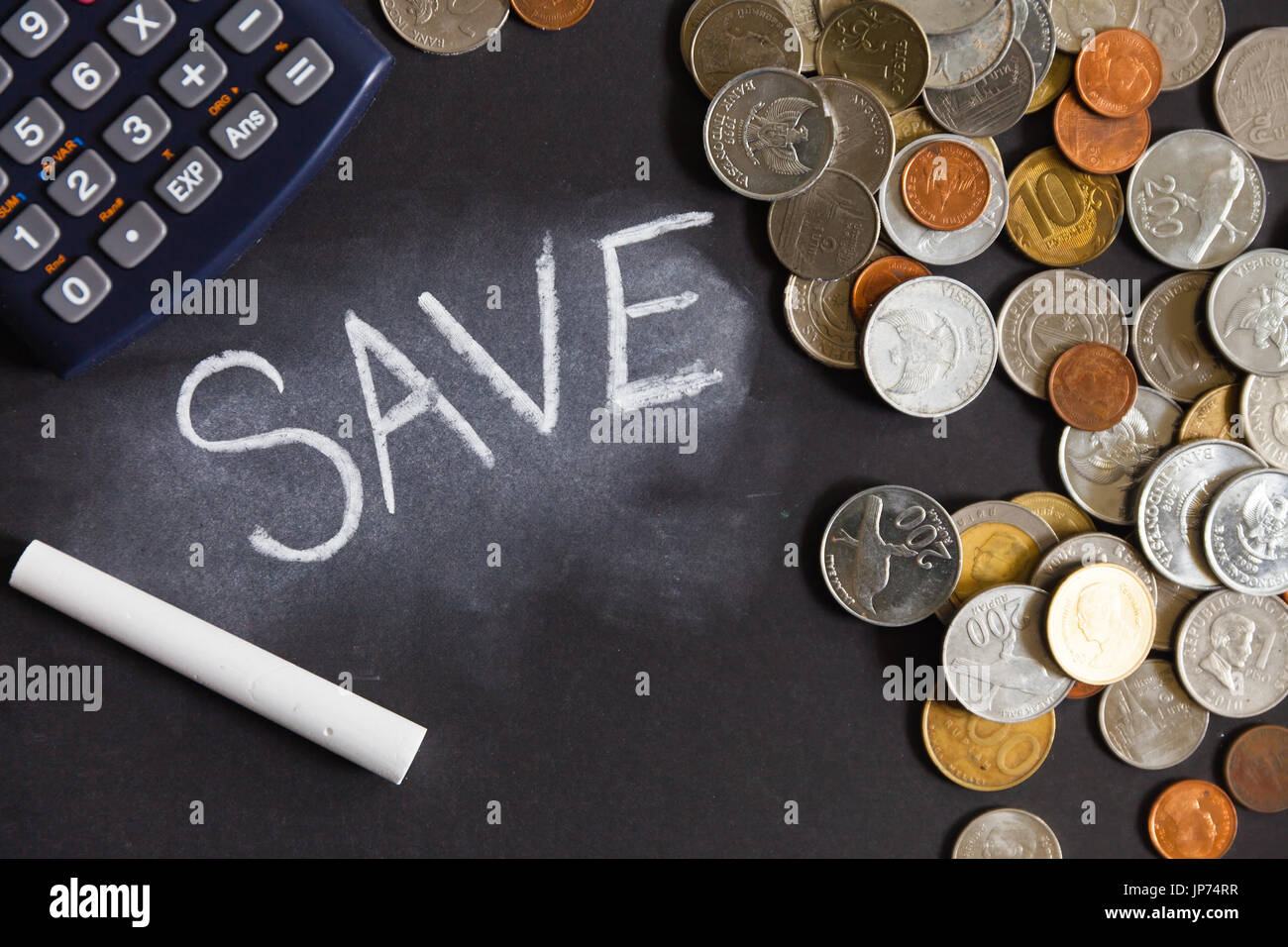 Money: Calculator and coins from different countries lying on a table ...