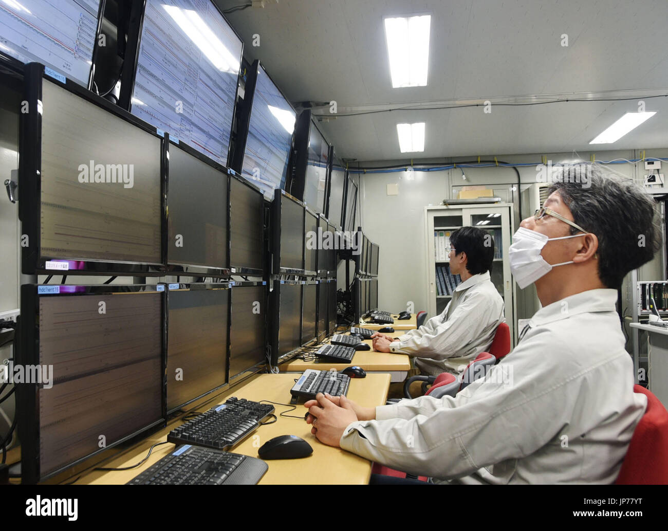 Workers at the Japan Proton Accelerator Research Complex monitor ...