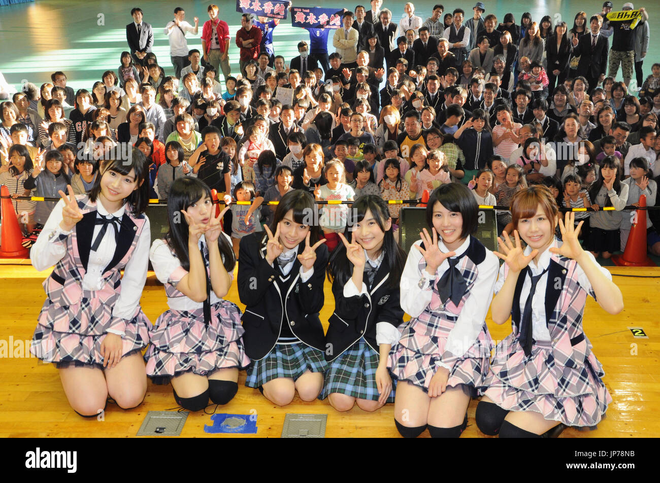 Members of the AKB48 Japanese all-girl pop group pose with students at ...